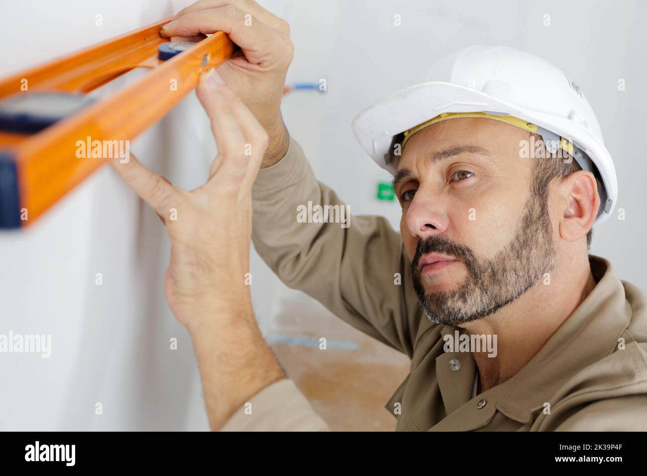 man measures on the wall with a ruler Stock Photo - Alamy