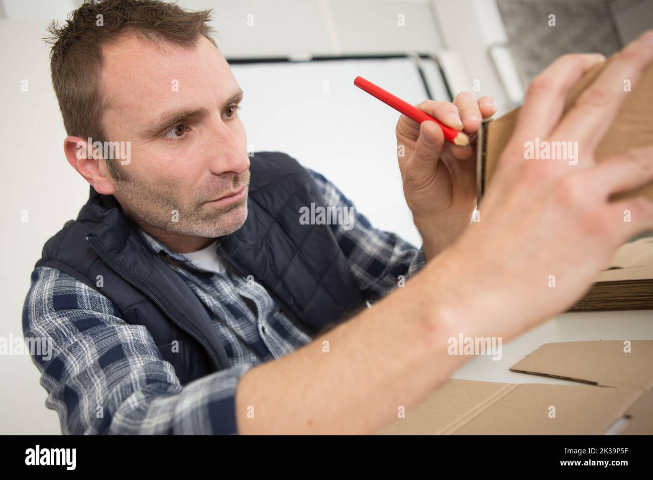 man making a pencil mark on cardboard box Stock Photo - Alamy