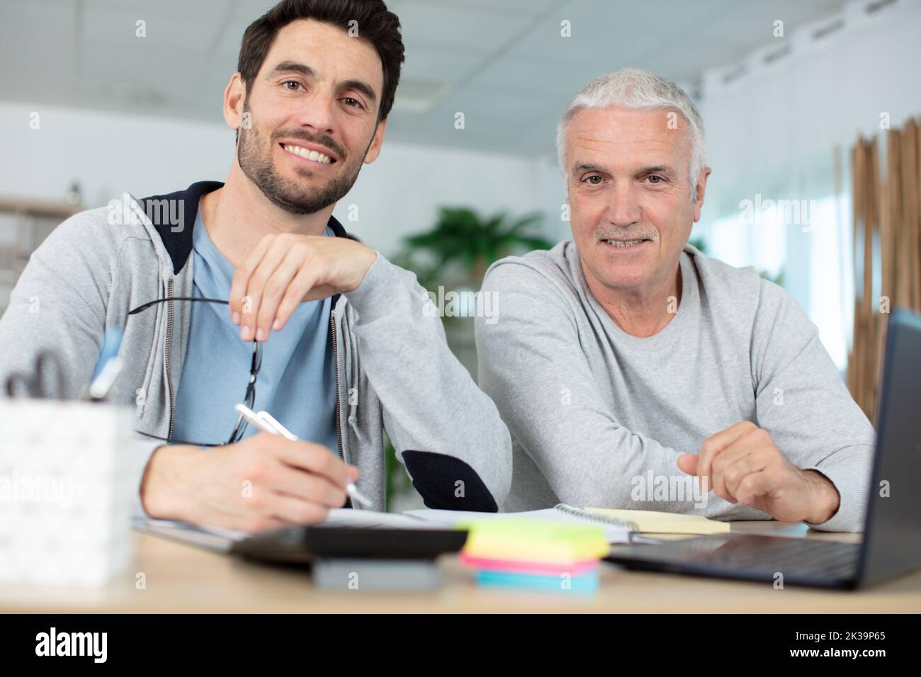 adult son with senior father at home accounting Stock Photo - Alamy