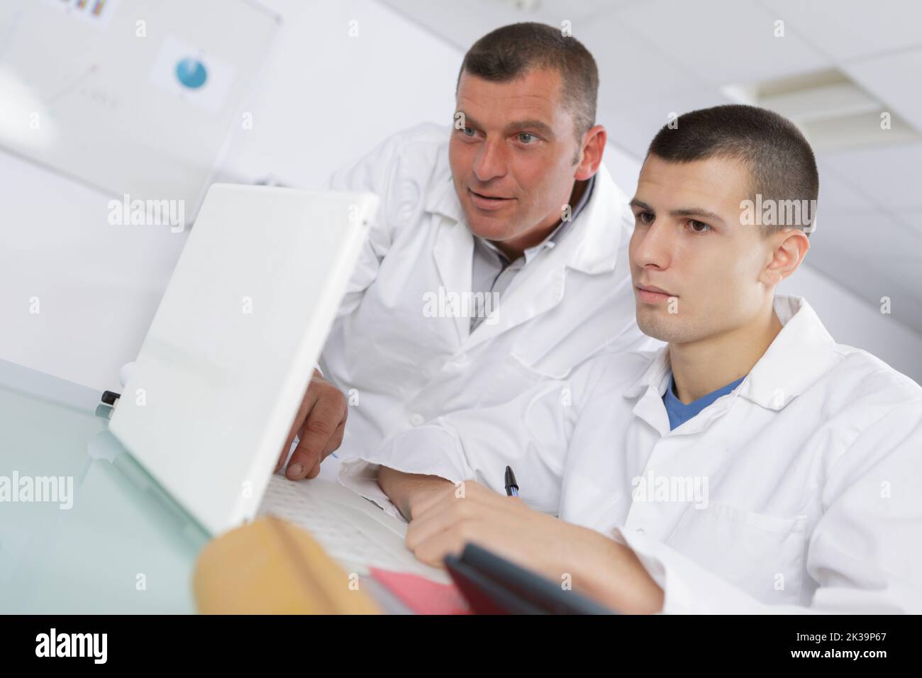 teacher watching student look in the computer Stock Photo - Alamy
