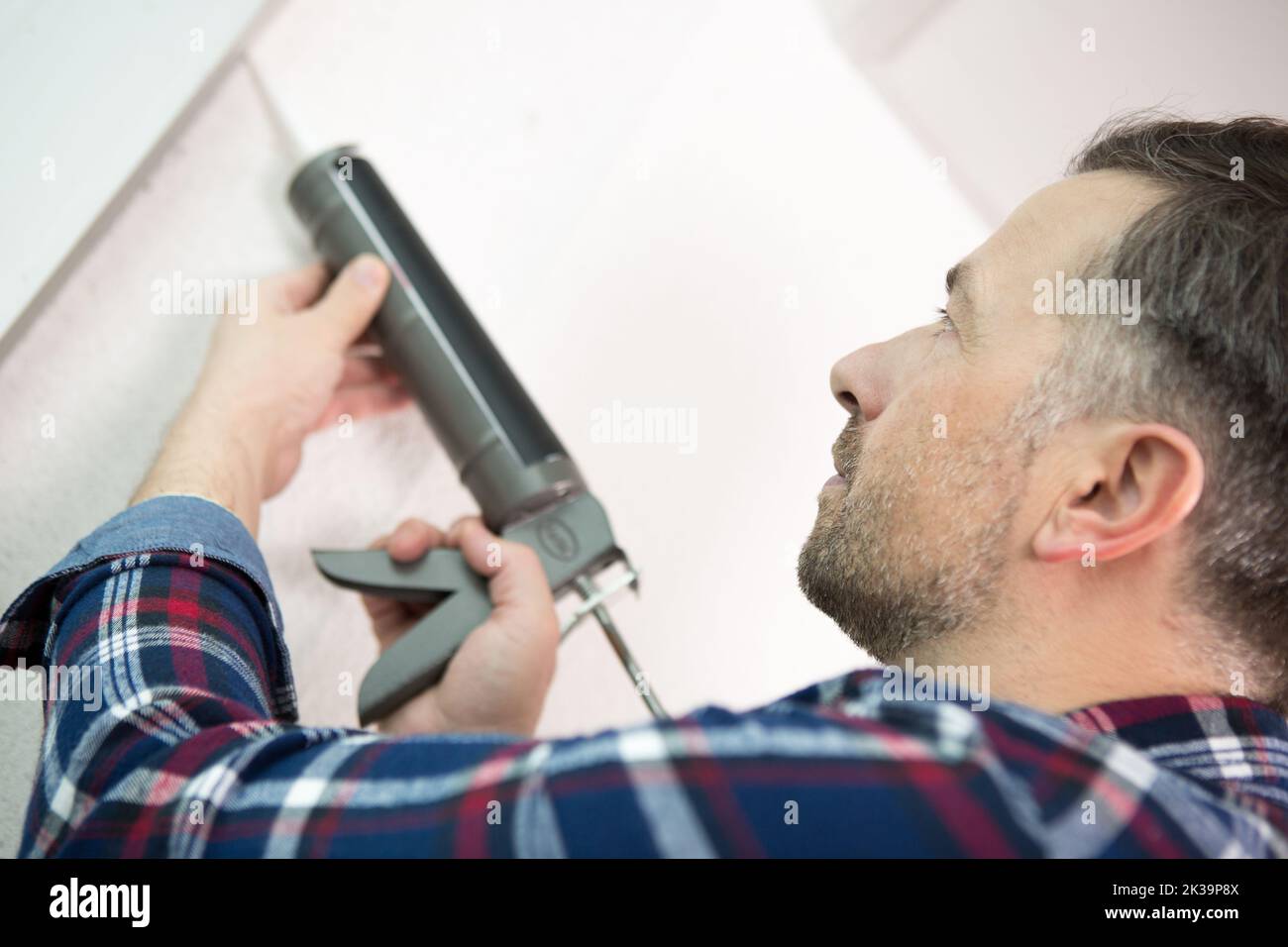 handyman applying sealant with a gun Stock Photo - Alamy