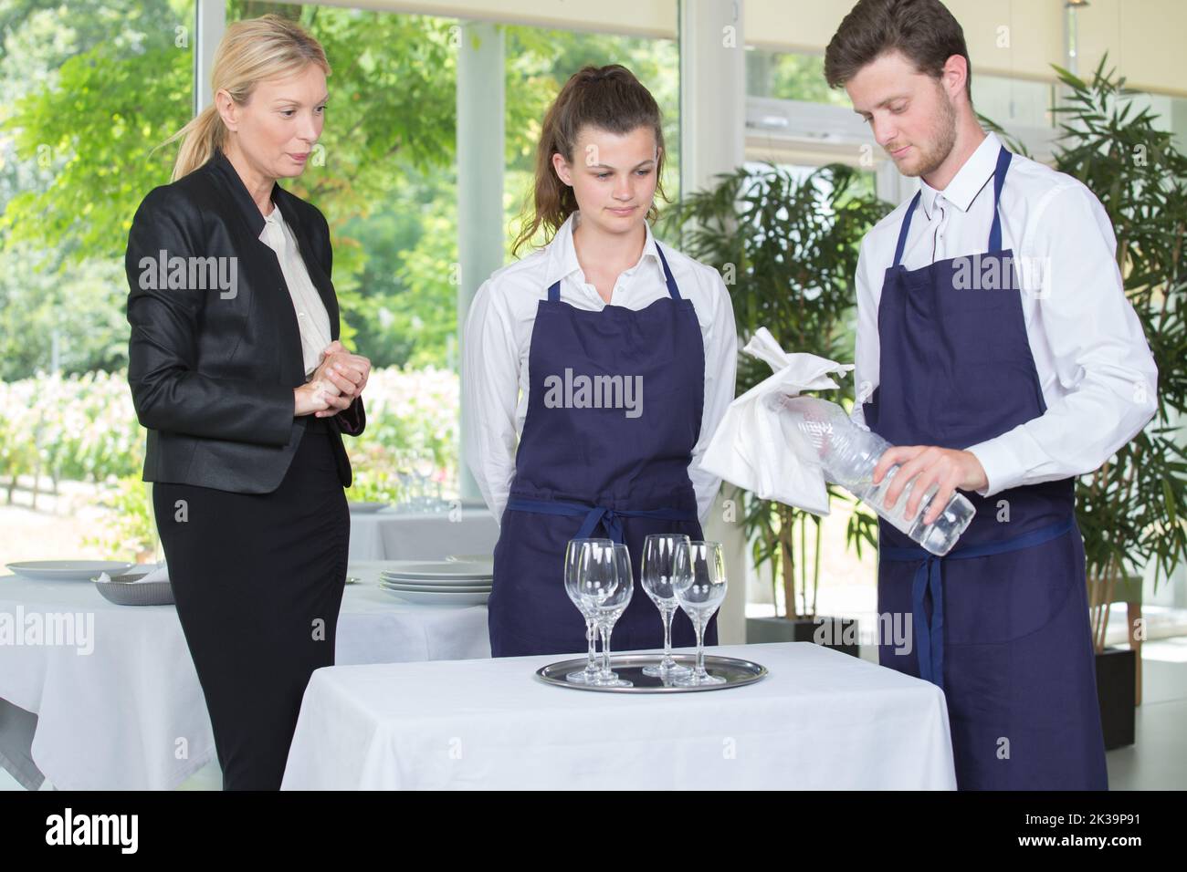 young waiter and waitress settings on the table Stock Photo - Alamy