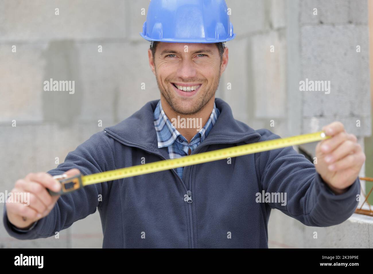 builder worker shows measures tape Stock Photo - Alamy