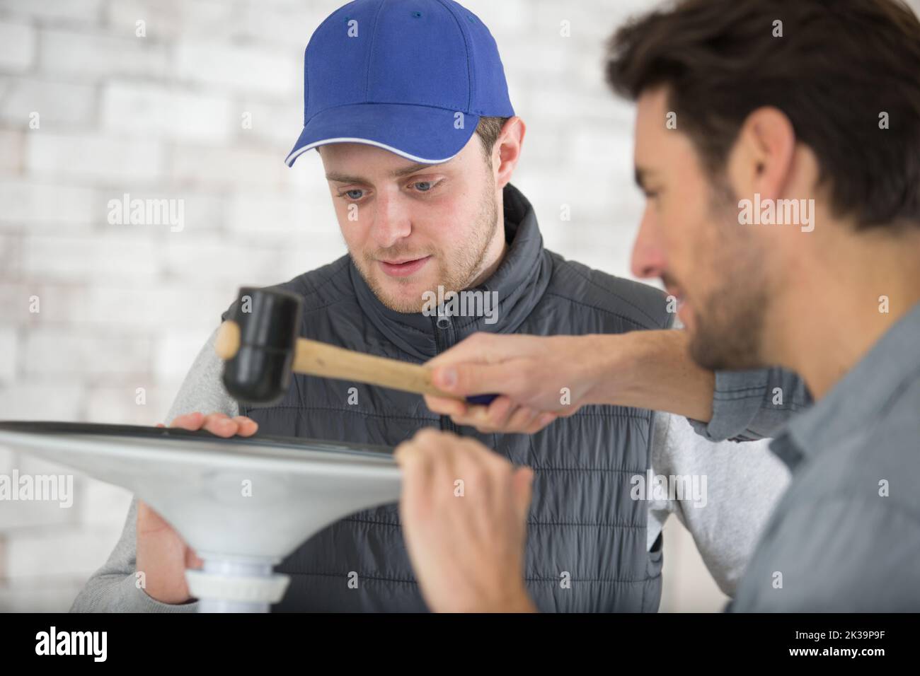 handyman using mallet to locate rubber seal onto seat base Stock Photo ...