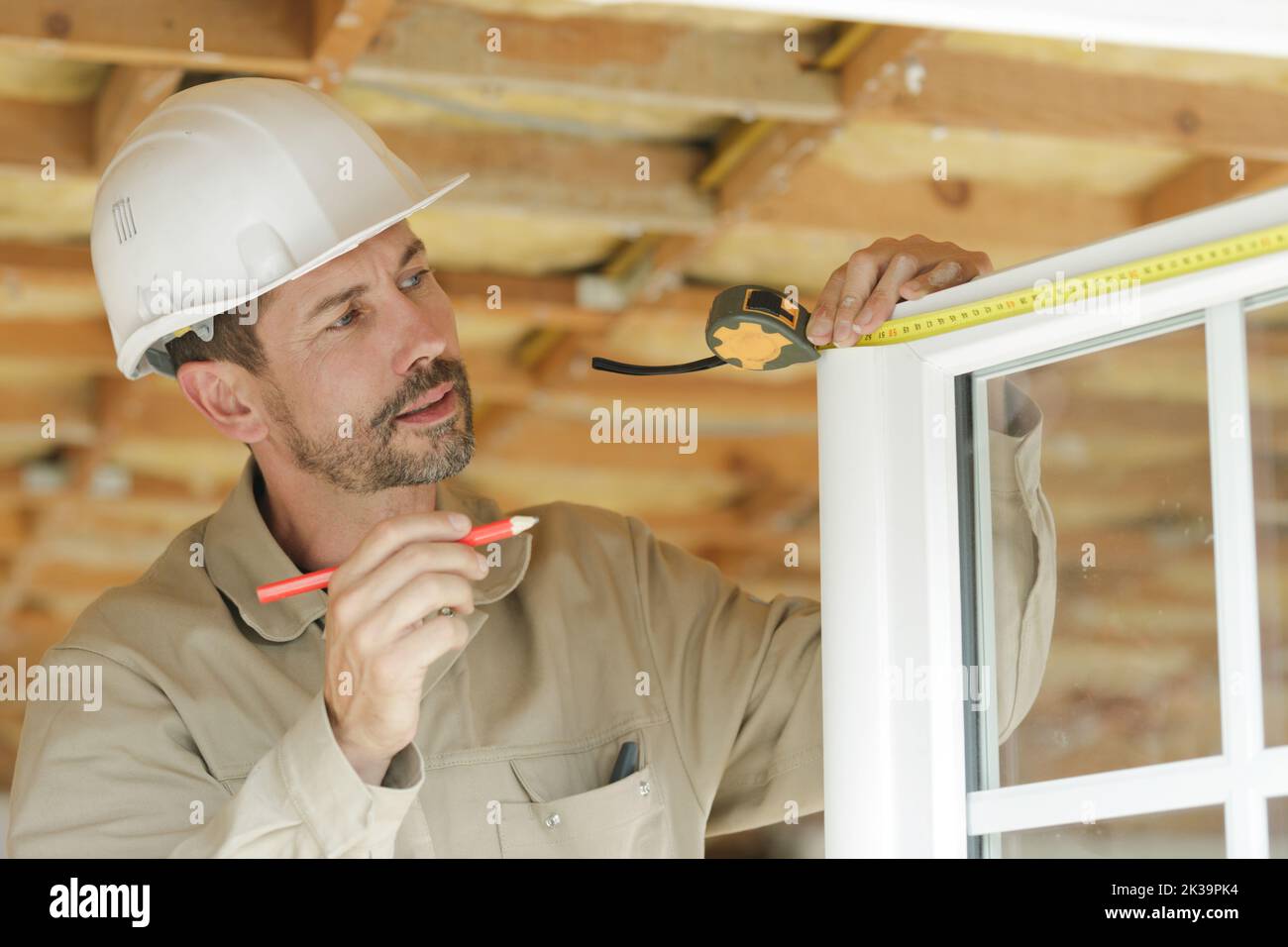 male builder measuring a frame Stock Photo - Alamy