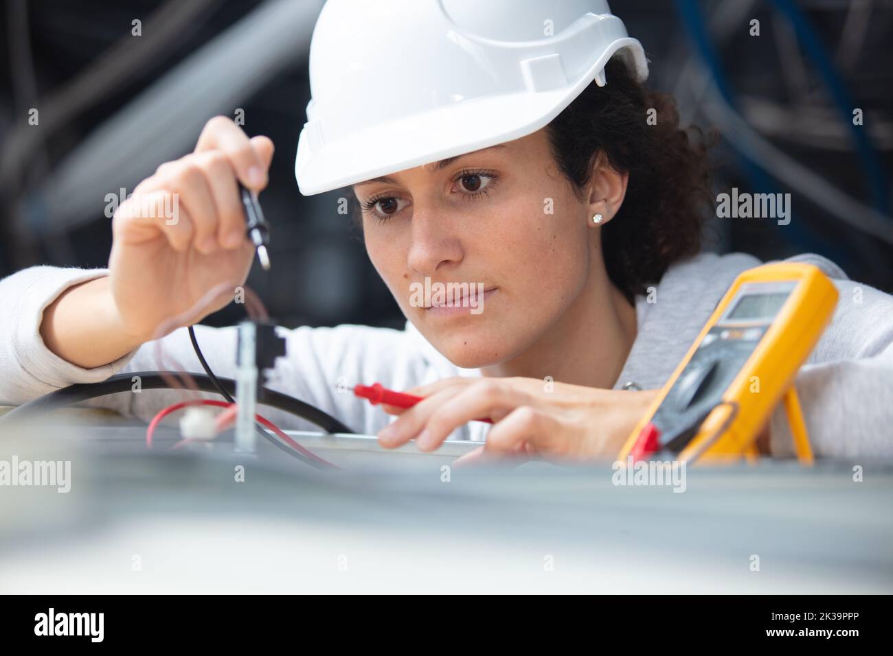 female electrician testing charge to spotlight Stock Photo - Alamy