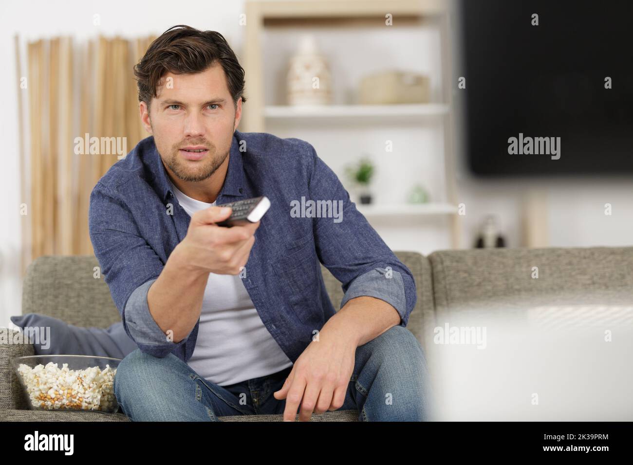 man using television remote control Stock Photo - Alamy