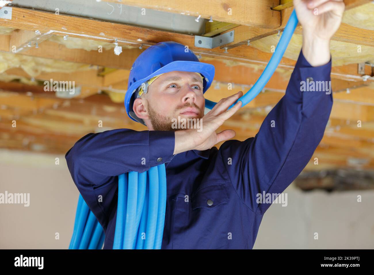 male builder installing pipes in the ceiling Stock Photo - Alamy
