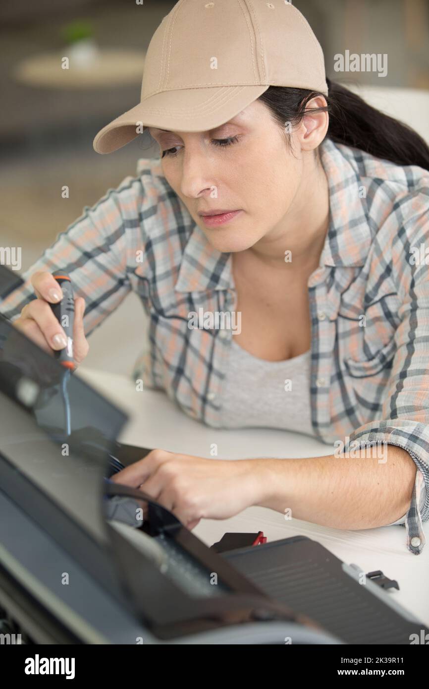 concentrated woman fixing a printer Stock Photo - Alamy