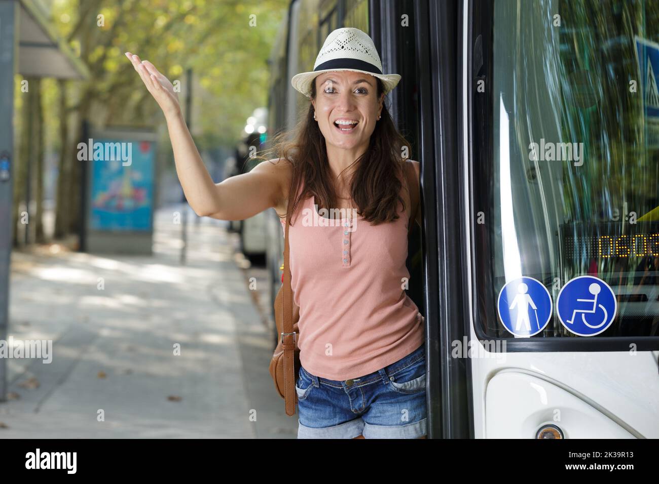 beautiful smiling waving young woman entering bus Stock Photo - Alamy