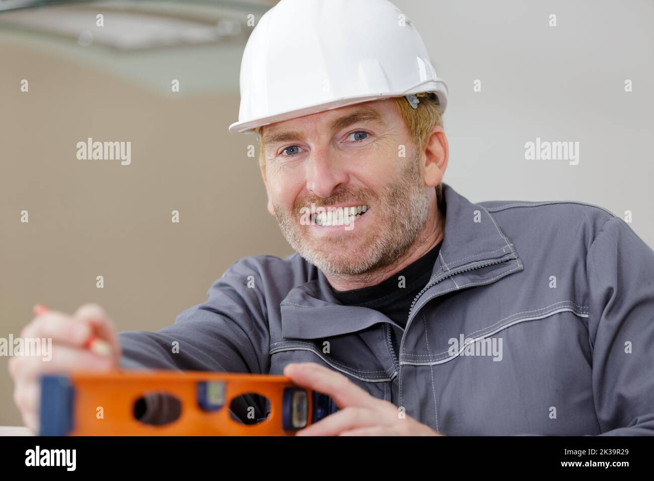 happy smiling constructor holding tool Stock Photo - Alamy
