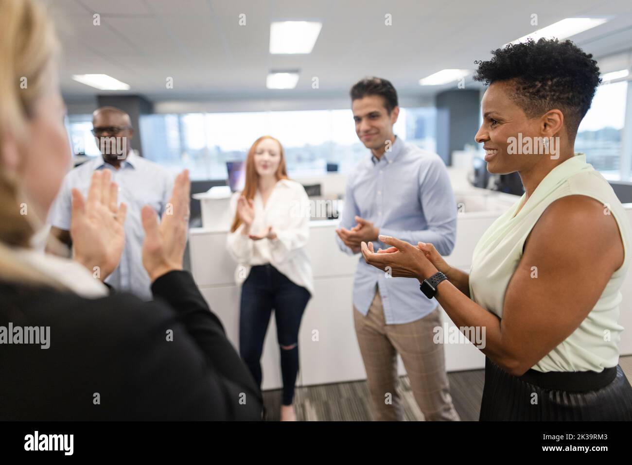Cheerful manager clapping hands in office coworking space Stock Photo ...