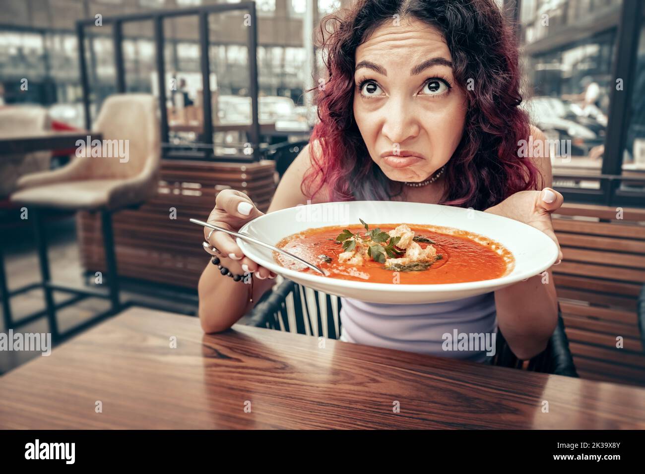 A woman dissatisfied customer of the restaurant sniffs the disgusting ...