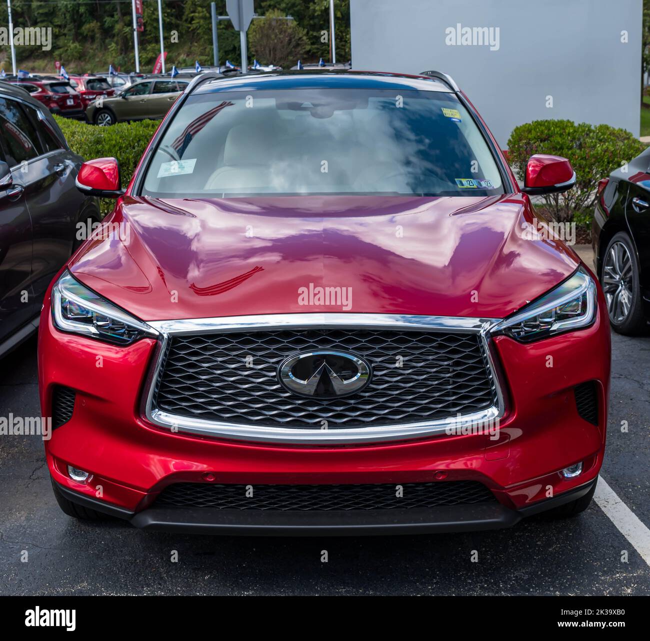 A red Infiniti car for sale at a dealership on a sunny fall day in ...