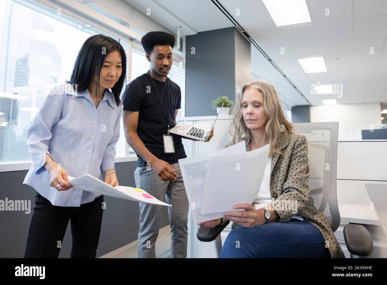 manager showing paperwork to colleagues in team meeting Stock Photo - Alamy