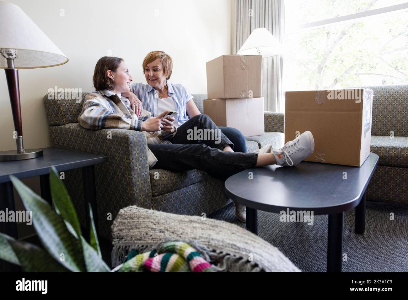 Mother And Daughter Taking A Break From Moving In College Dorm Room