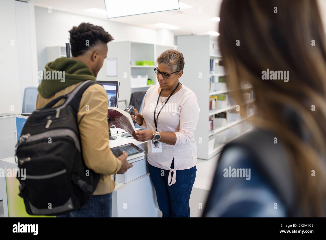 Woman helping man in library hi-res stock photography and images - Alamy