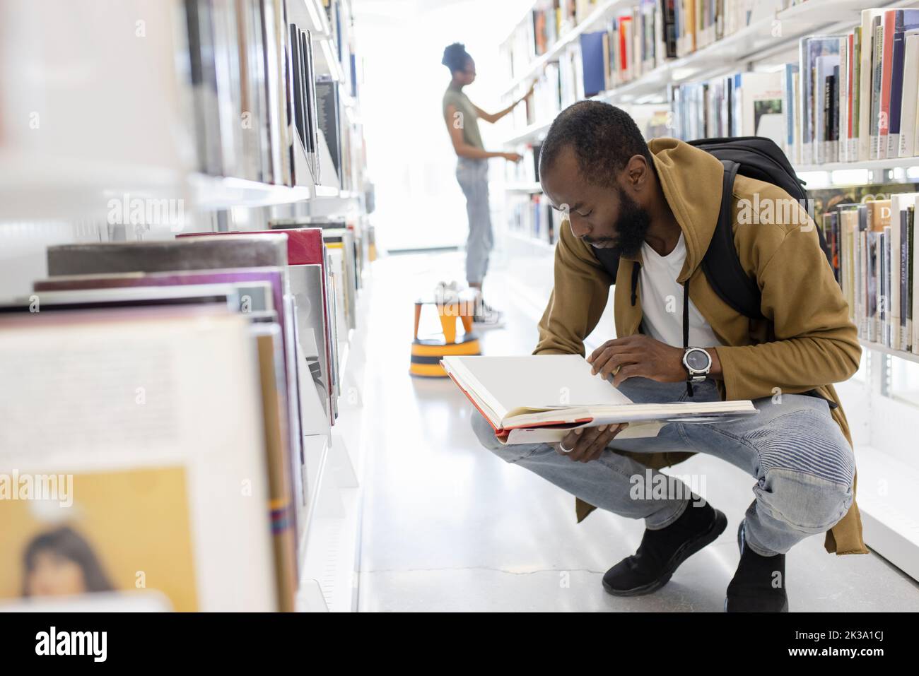 Man in library reading book hi-res stock photography and images - Alamy