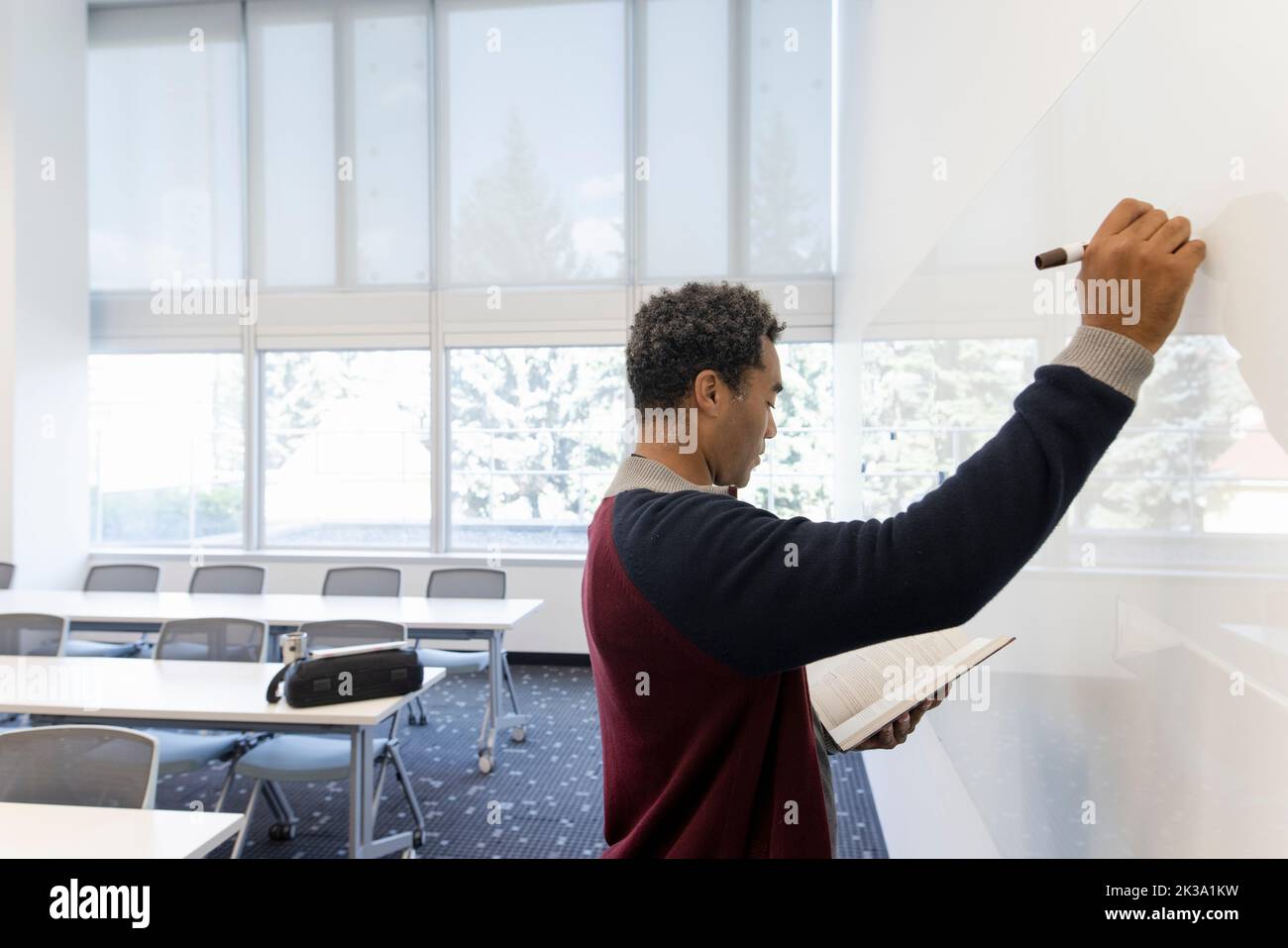 Male classroom teacher holding book hi-res stock photography and images ...