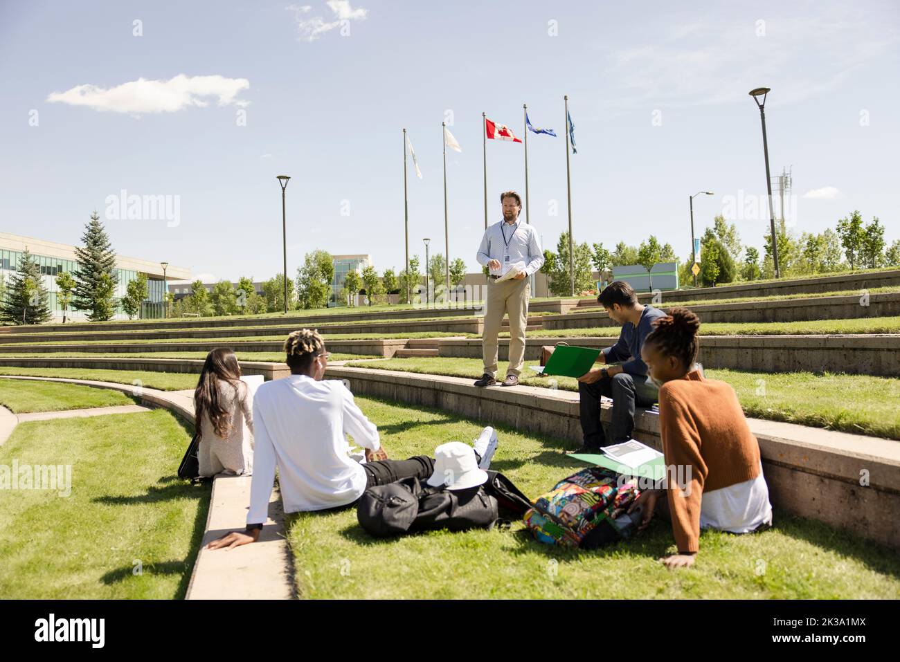 Students sitting on grass with teacher hi-res stock photography and ...