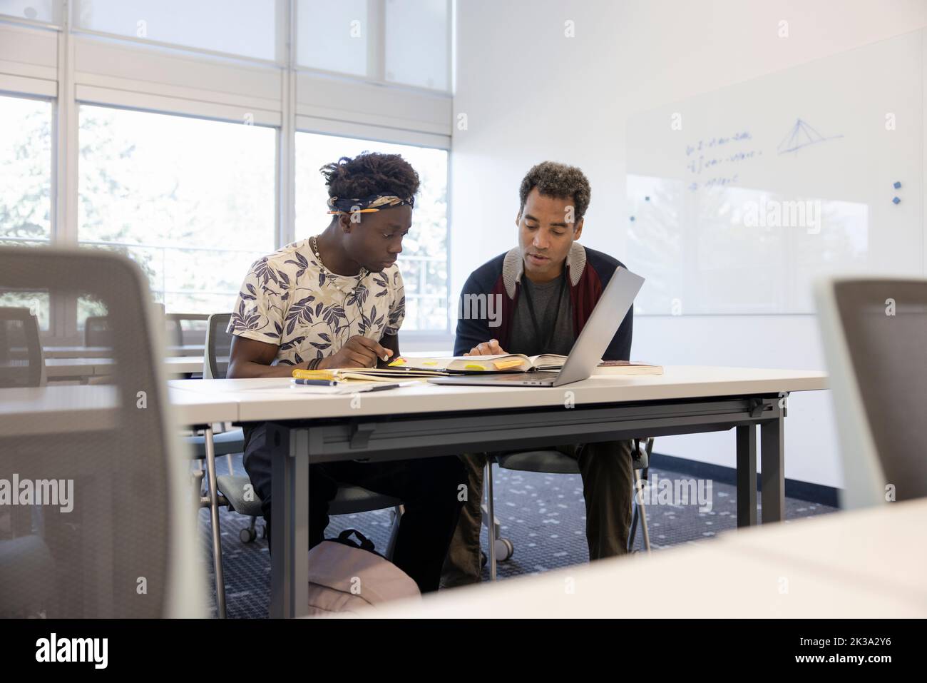 Male college professor and student talking in classroom Stock Photo - Alamy