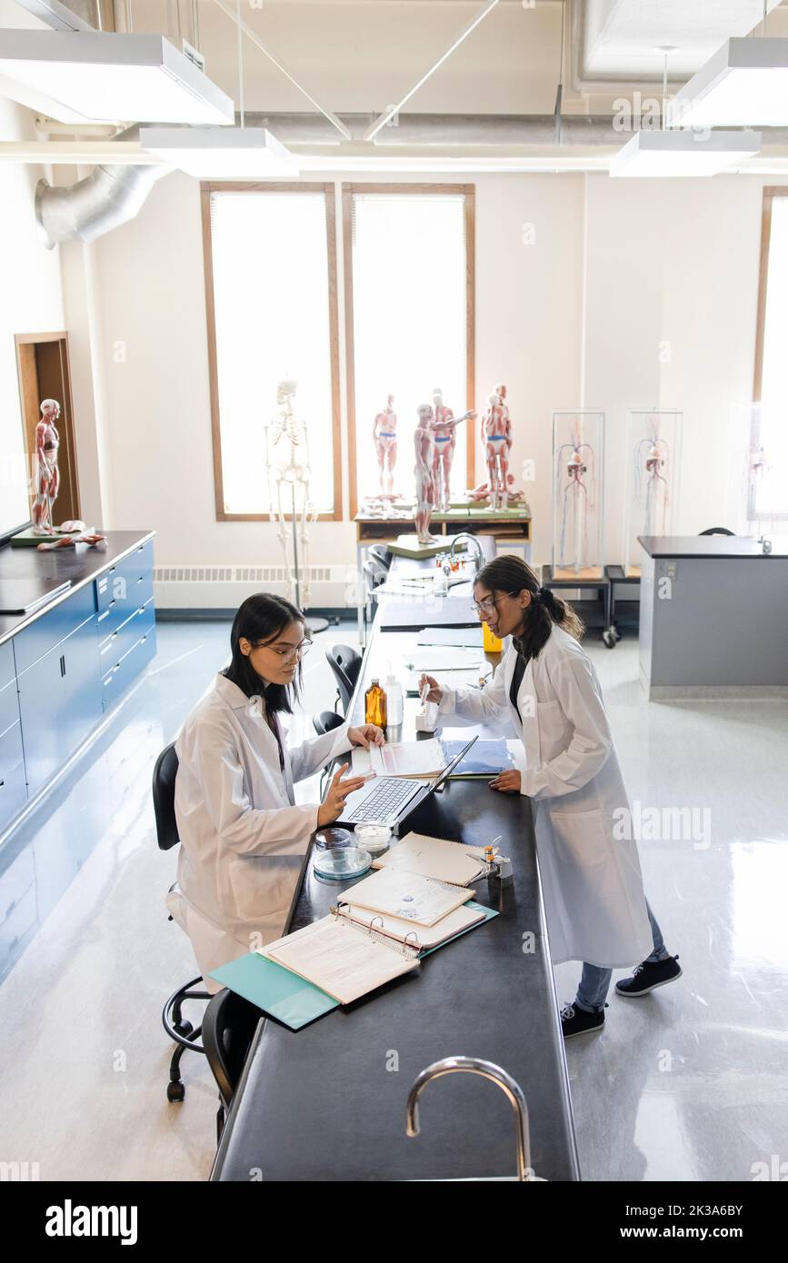 Female college students researching in science laboratory Stock Photo ...