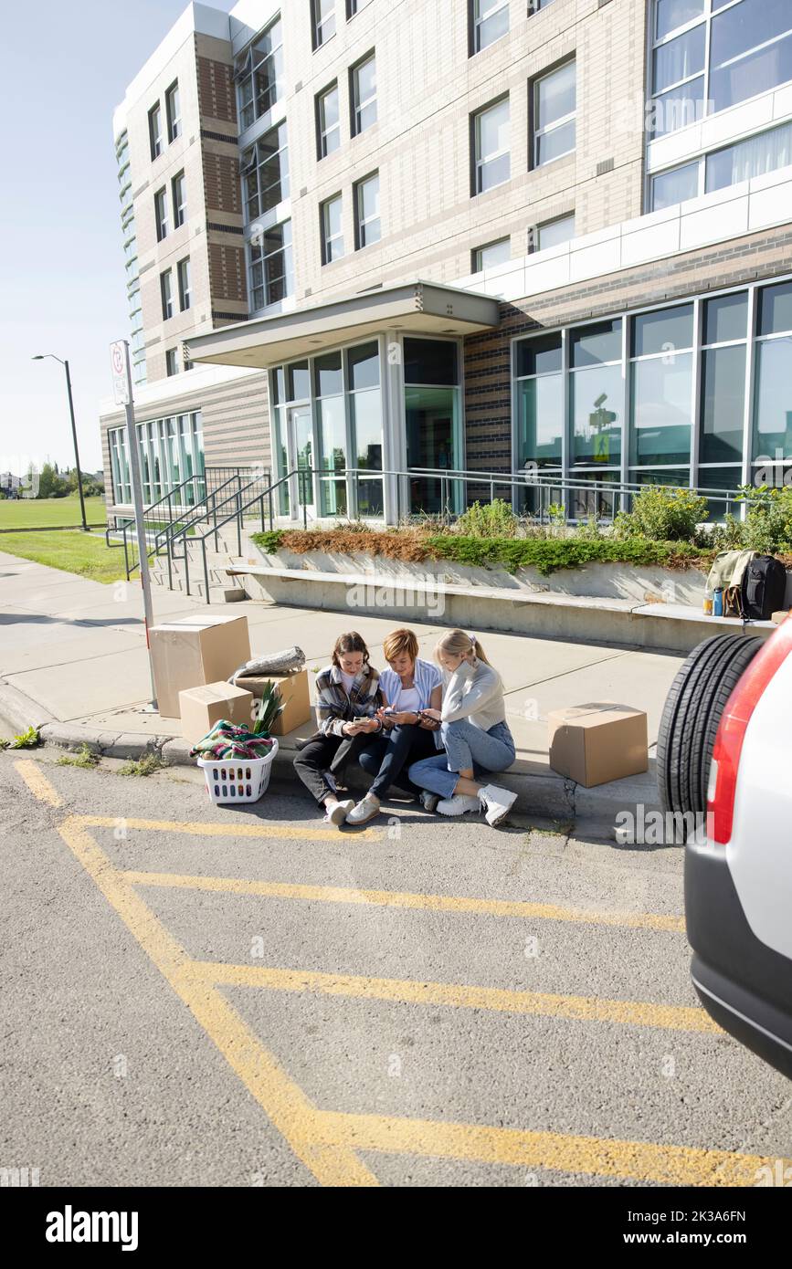 Mother And College Daughters Taking Break From Moving Into Dorm Stock