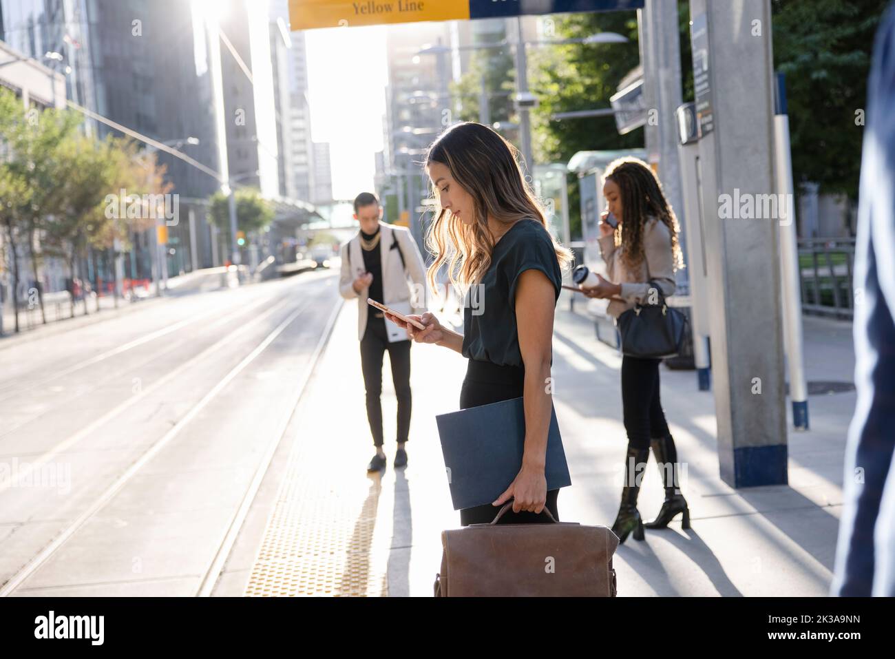 Mixed race office worker waiting for train Stock Photo - Alamy