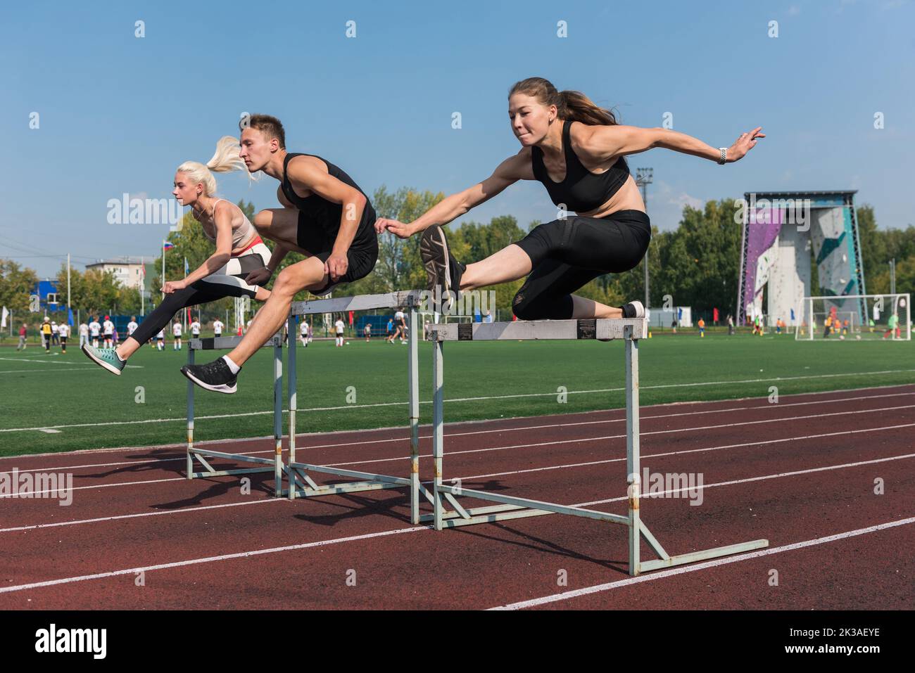 Two athlete woman and man runnner running hurdles at the stadium ...