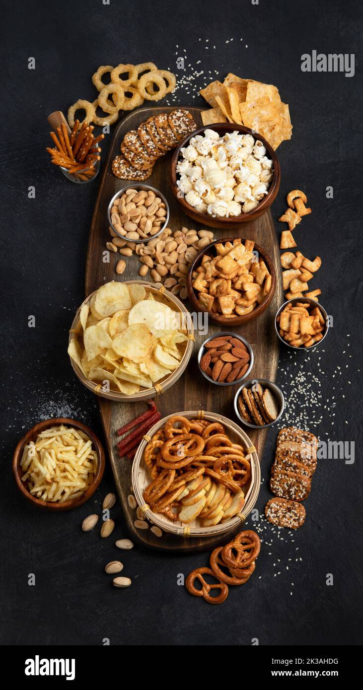Assortment of salty snacks on dark background. Party food concept. Top ...
