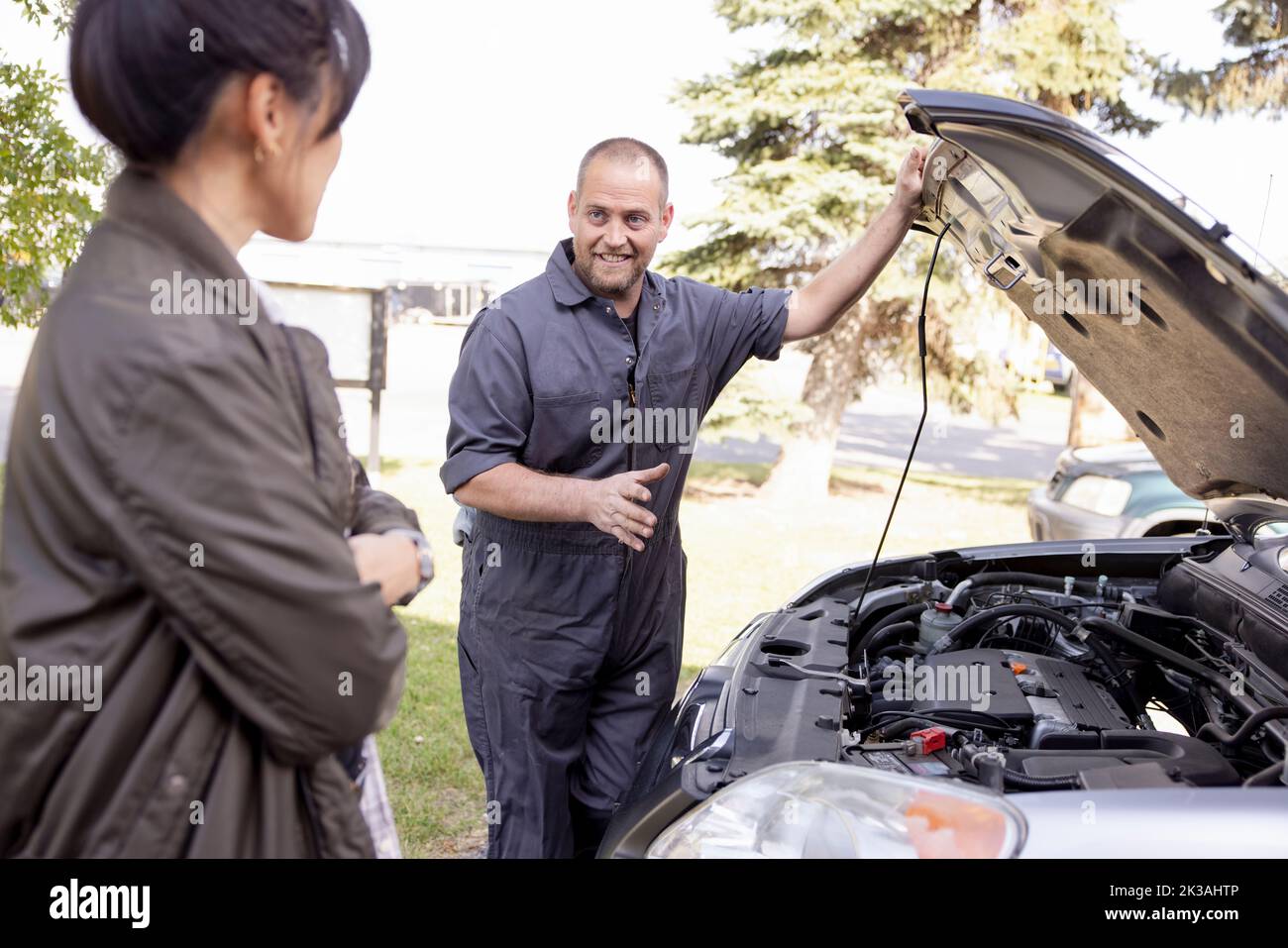 Mechanic standing beside open car hood hi-res stock photography and ...