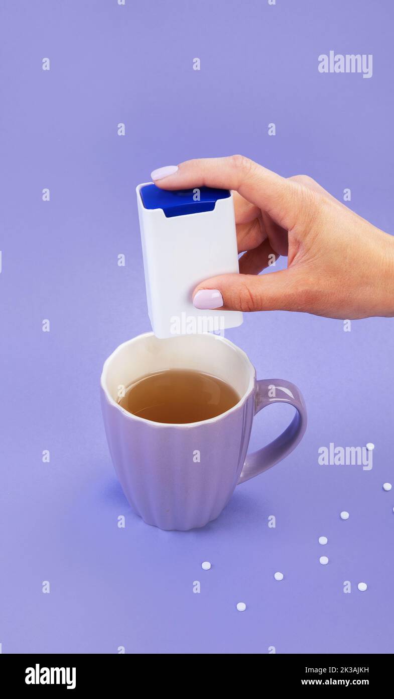 Hand with box sweetener tablets. Cup of tea. Artificial sugar on a ...