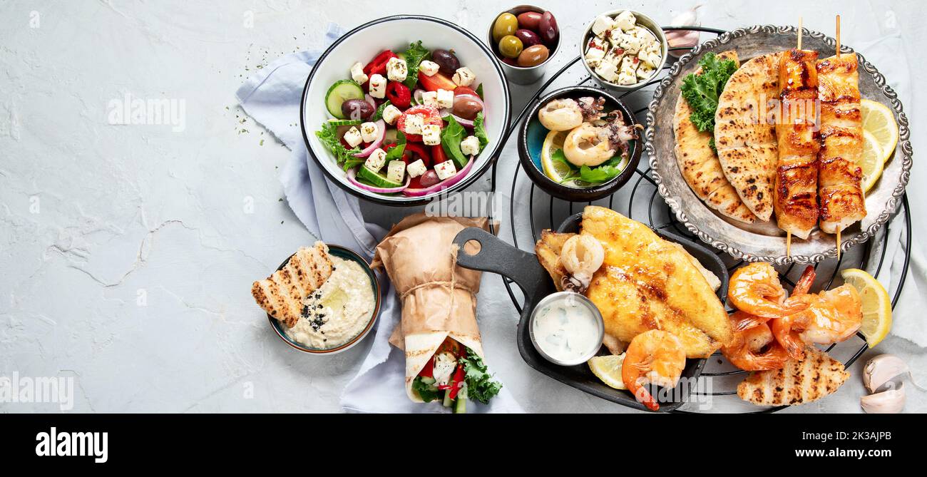 Greek food background. Meze, gyros, souvlaki, fish, pita, greek salad ...
