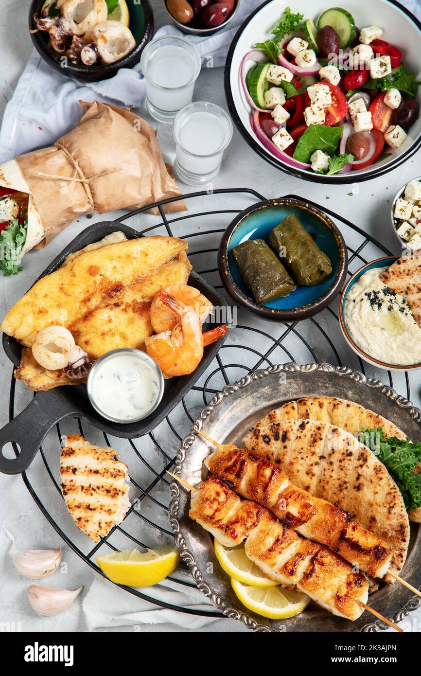 Greek food background. Meze, gyros, souvlaki, fish, pita, greek salad ...
