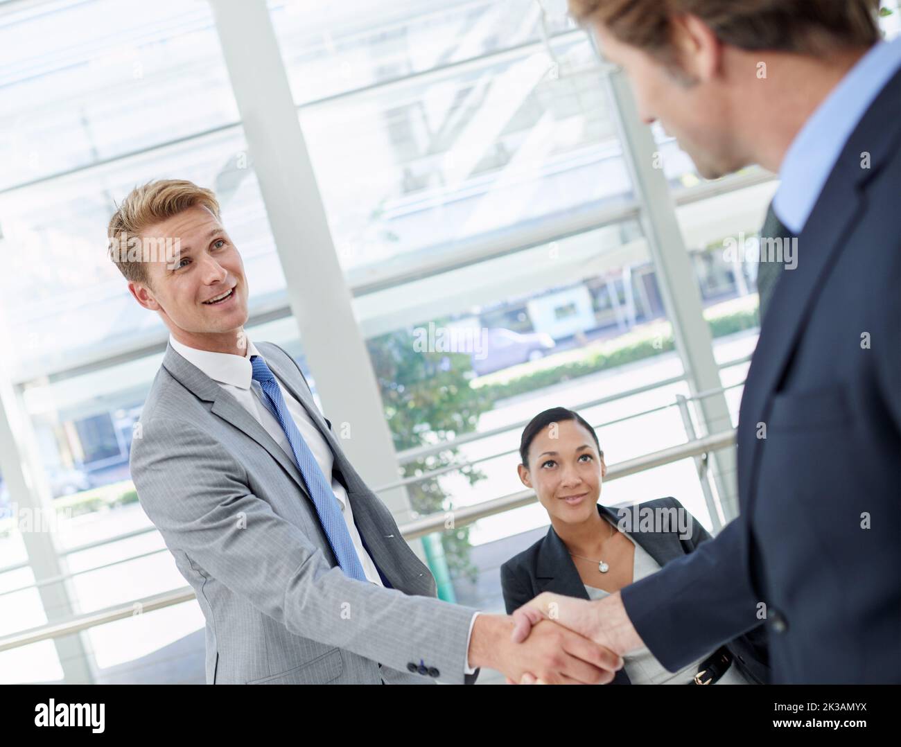 Hes moving up in the company. two businessmen shaking hands in an ...