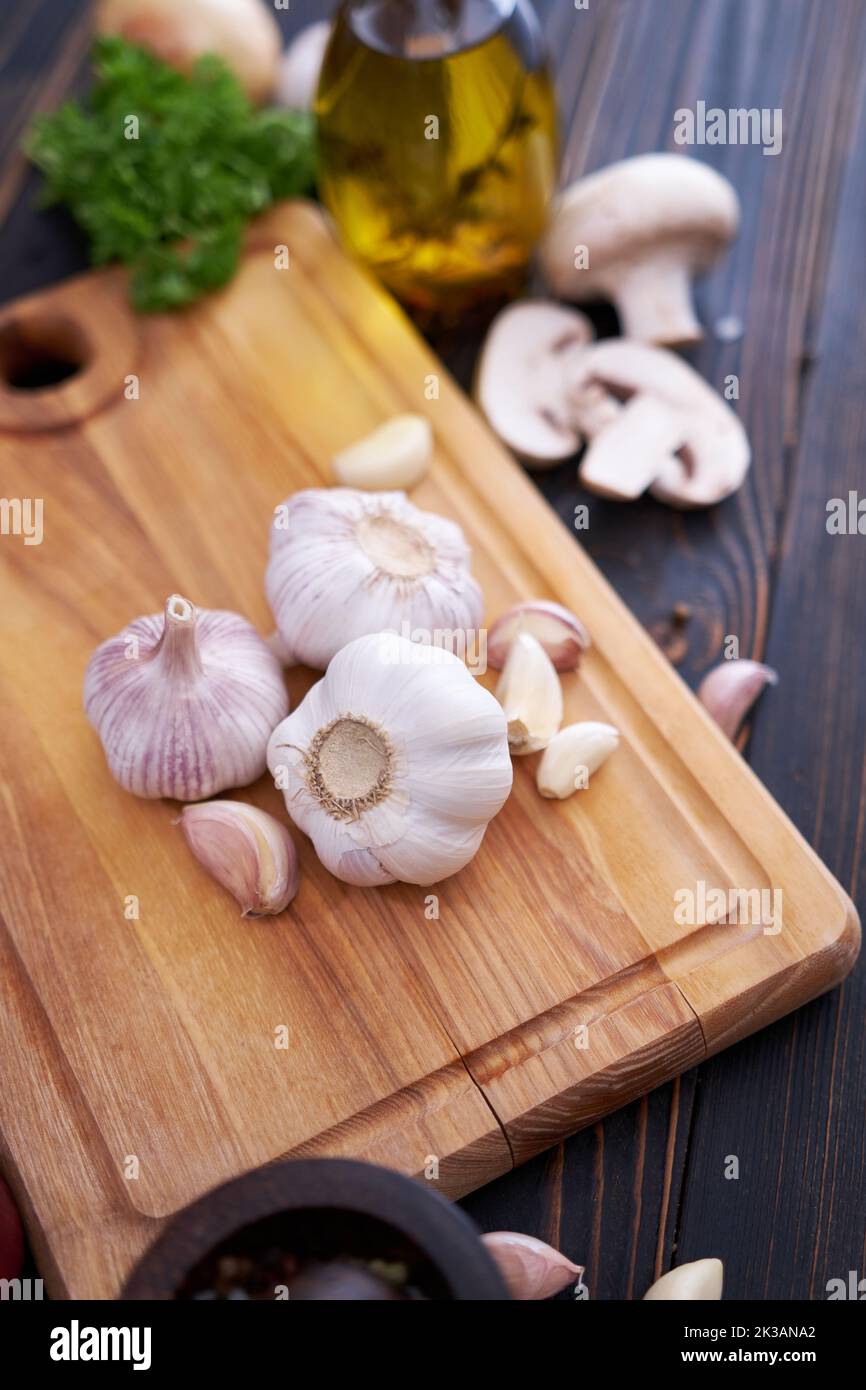 Garlic on wooden chopping board on wooden background or table Stock ...