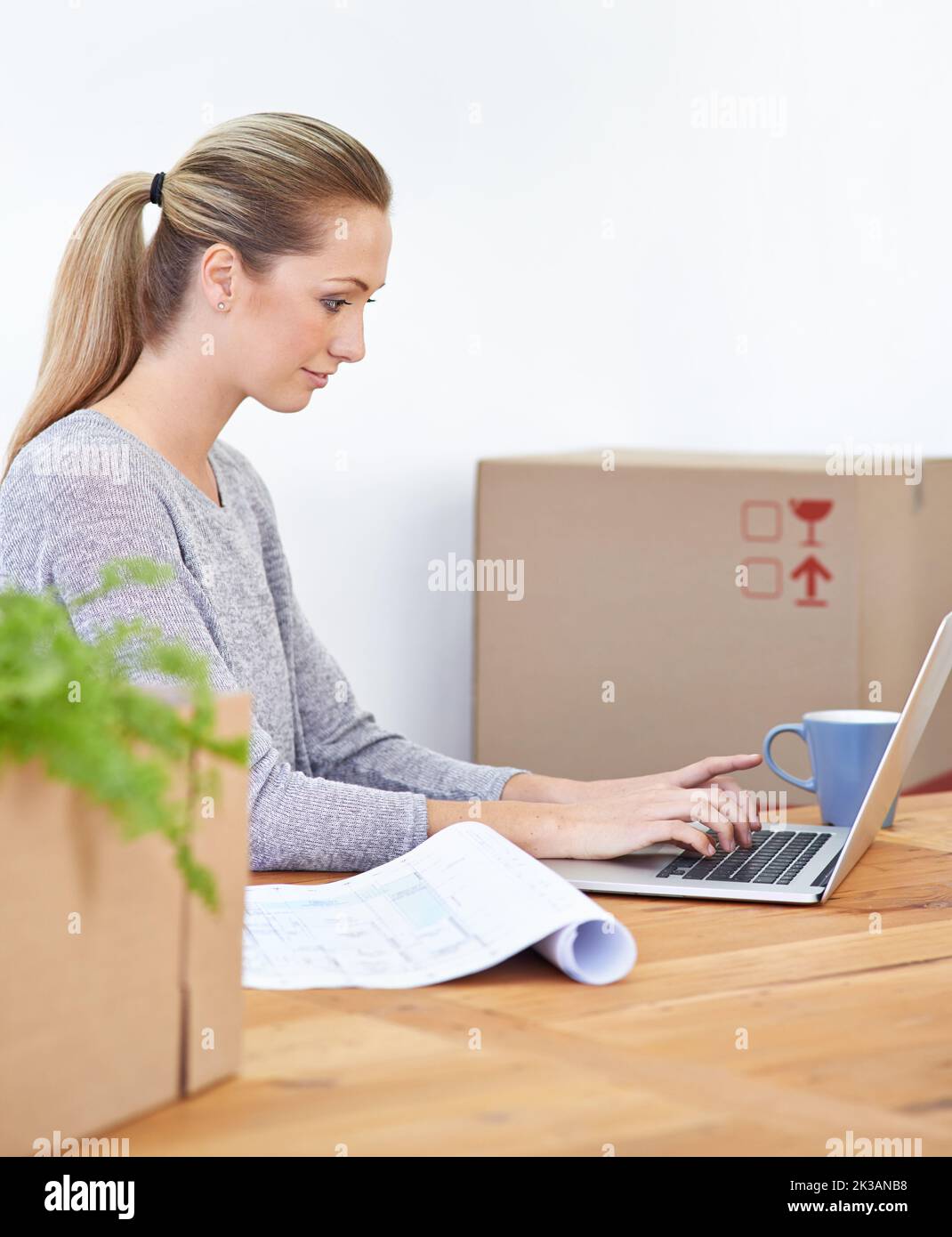 Work doesnt stop because youre moving. A young woman working in her new ...