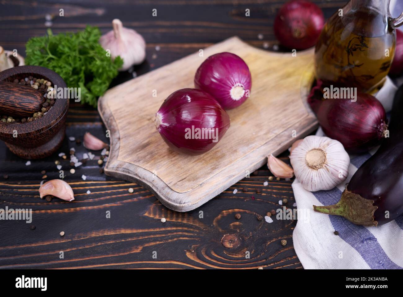 Red Onion on wooden cutting board with dark background Stock Photo - Alamy