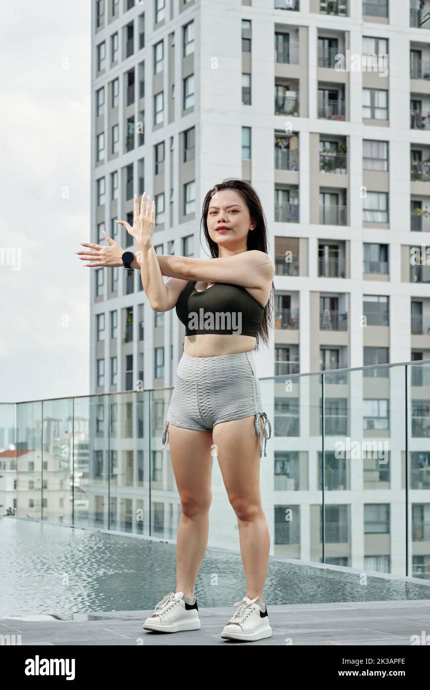 Photo realistic digital collage of sportswoman exercising on rooftop of ...
