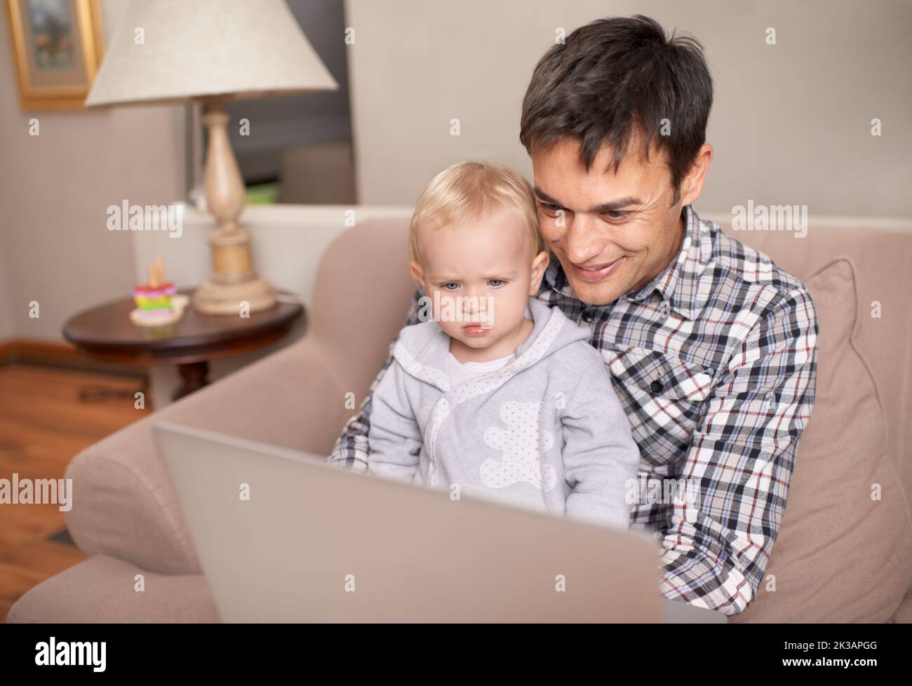 Showing dad how its done. A young father showing his baby girl how a ...