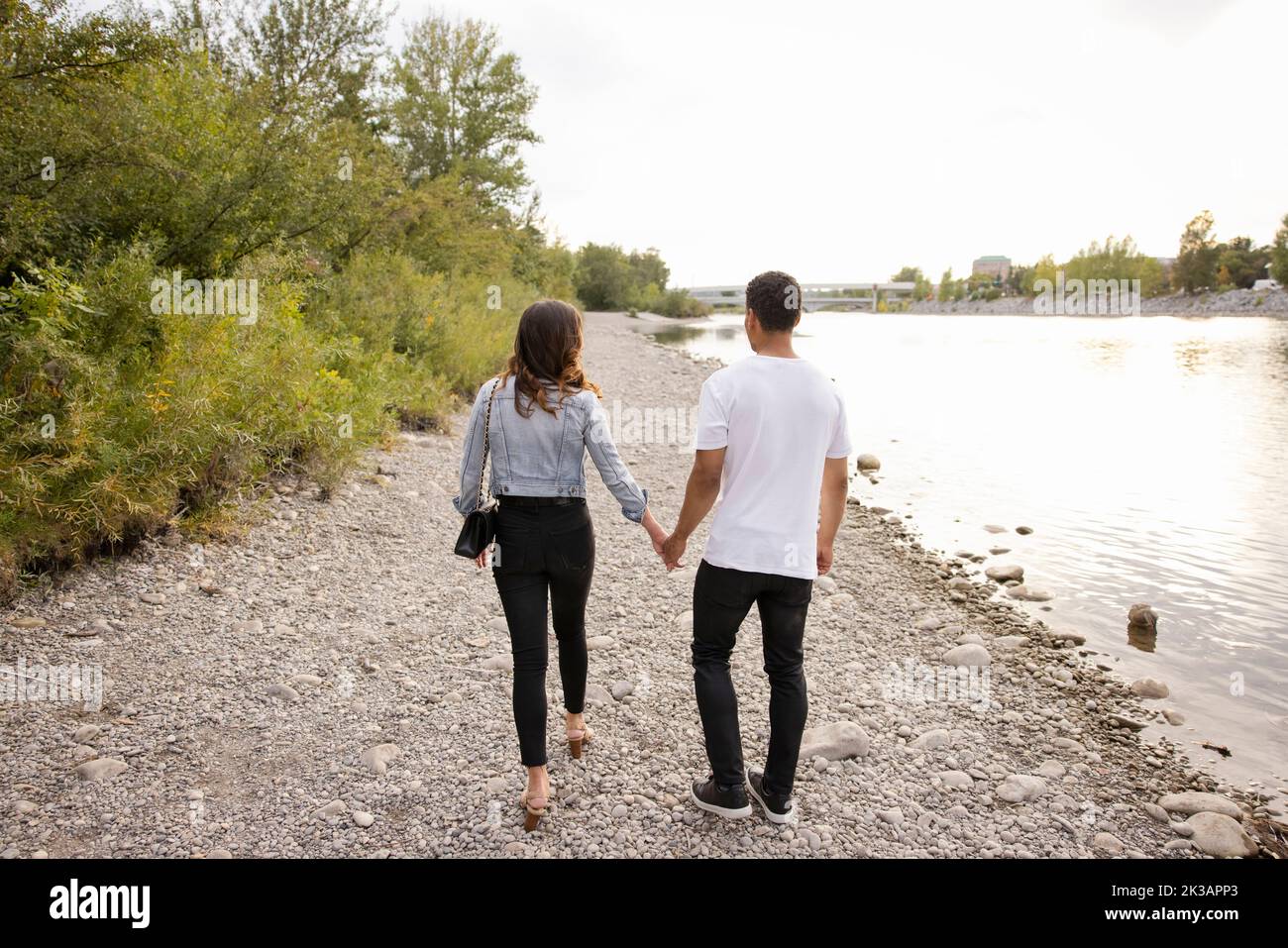 Affectionate couple holding hands at riverbank Stock Photo - Alamy