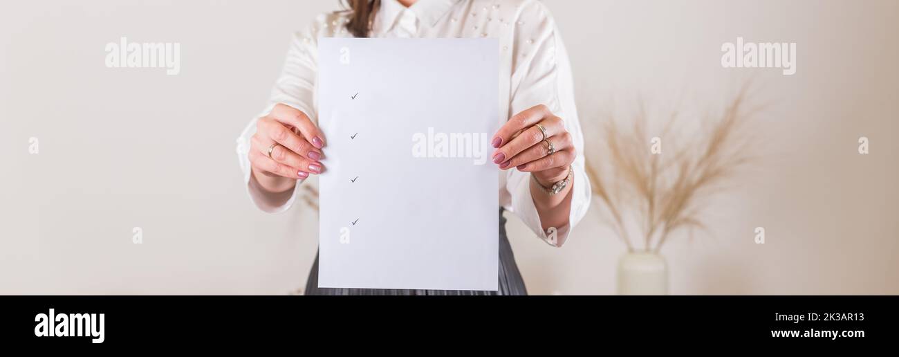Woman holding a blank sheet of paper with check marks. Blank paper ...