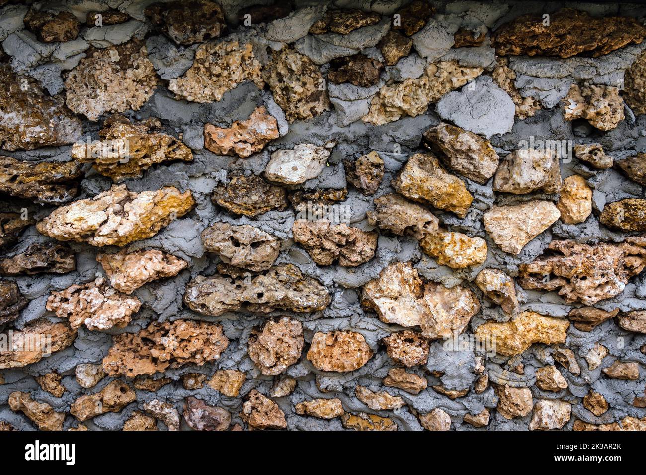 Old style wall made of rough stones with cement. Ancient grunge stones ...