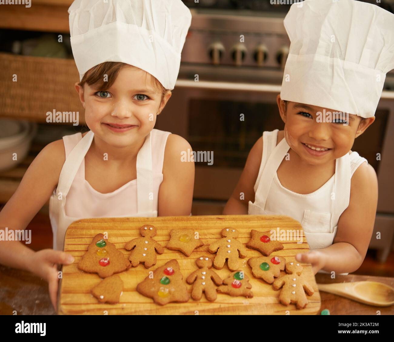 Baking is so much fun. Portrait of two little girls showing off the ...