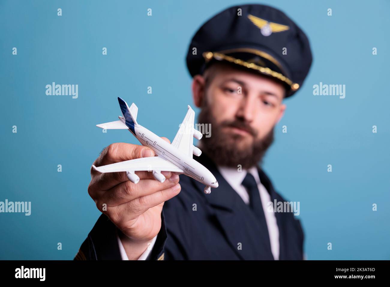 Airplane aviator in aircrew uniform looking at plane model, pilot ...