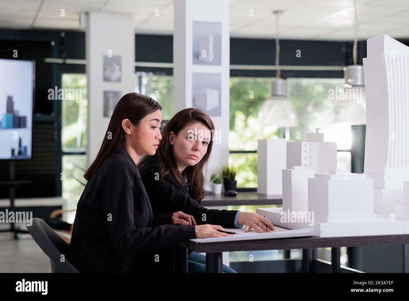Architects working with blueprints, discussing city building 3d printed ...