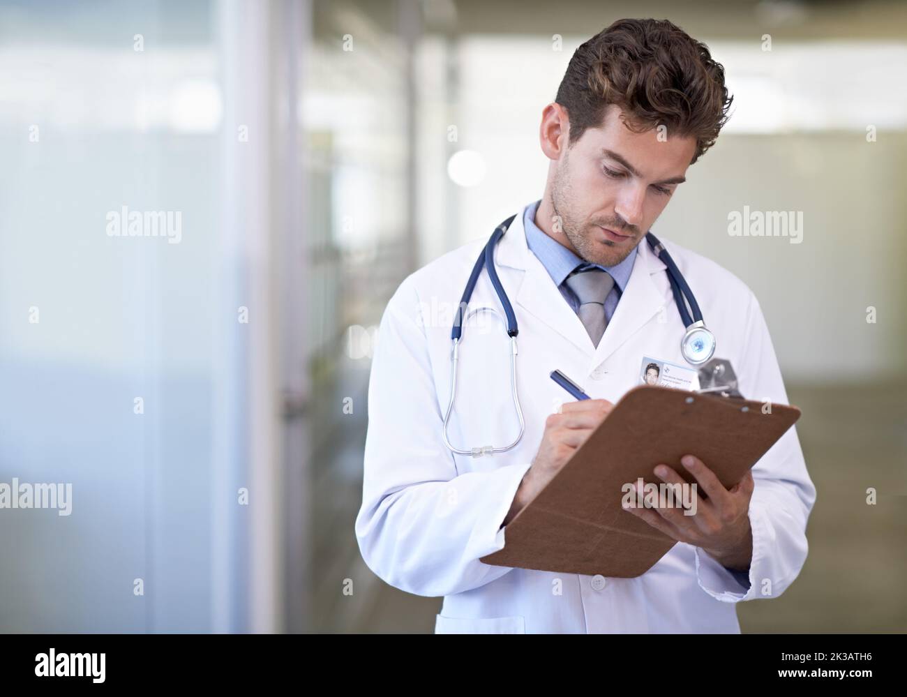 Signing off on treatments. a handsome young doctor Stock Photo - Alamy