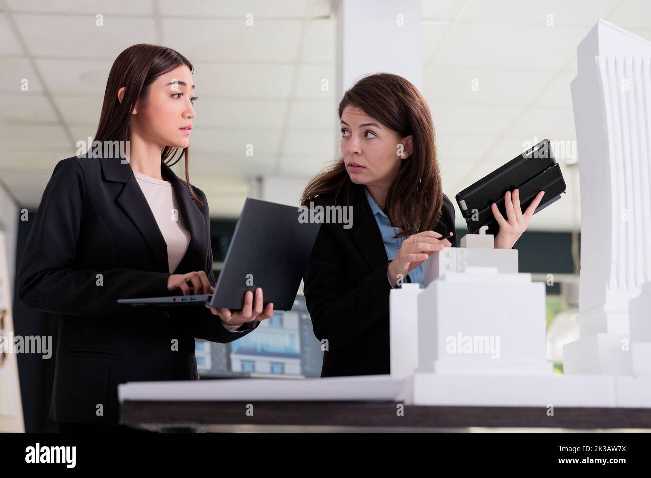 Architects discussing 3d building model, using architectural software ...