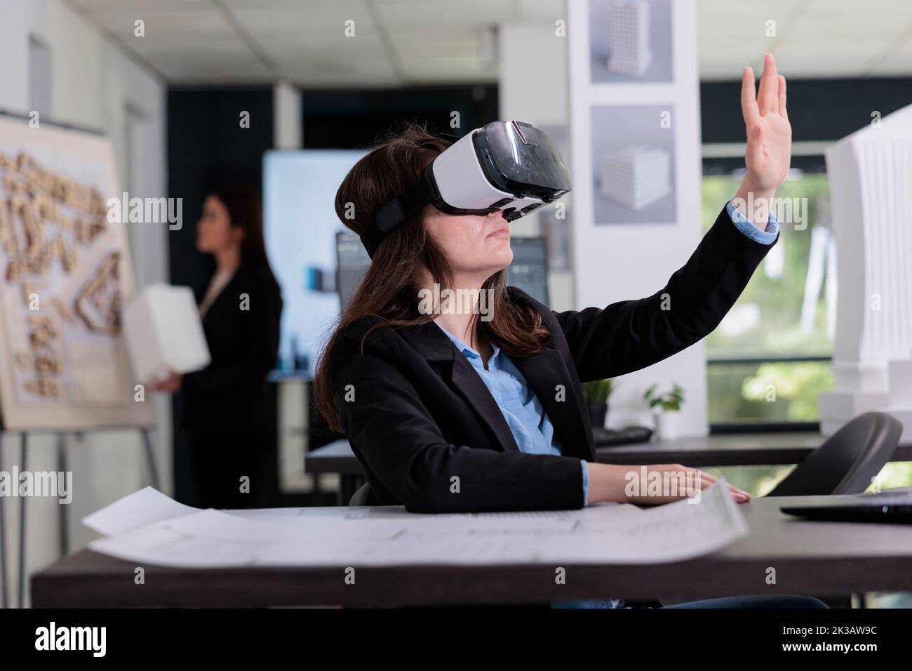 Architect in ar helmet touching virtual building model, working on ...