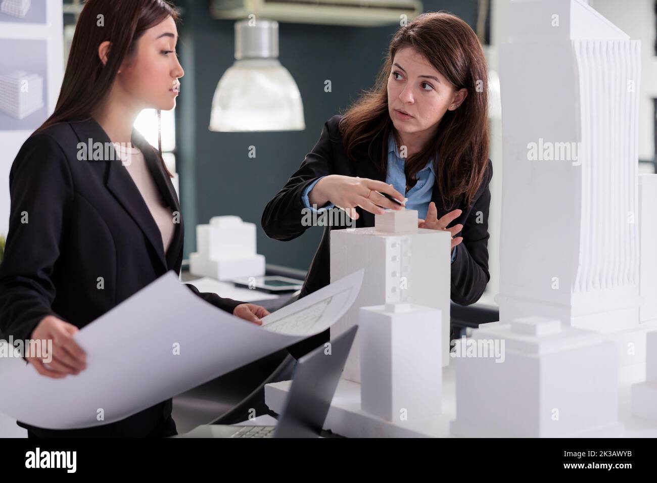 Architects discussing blueprint, holding building construction project ...